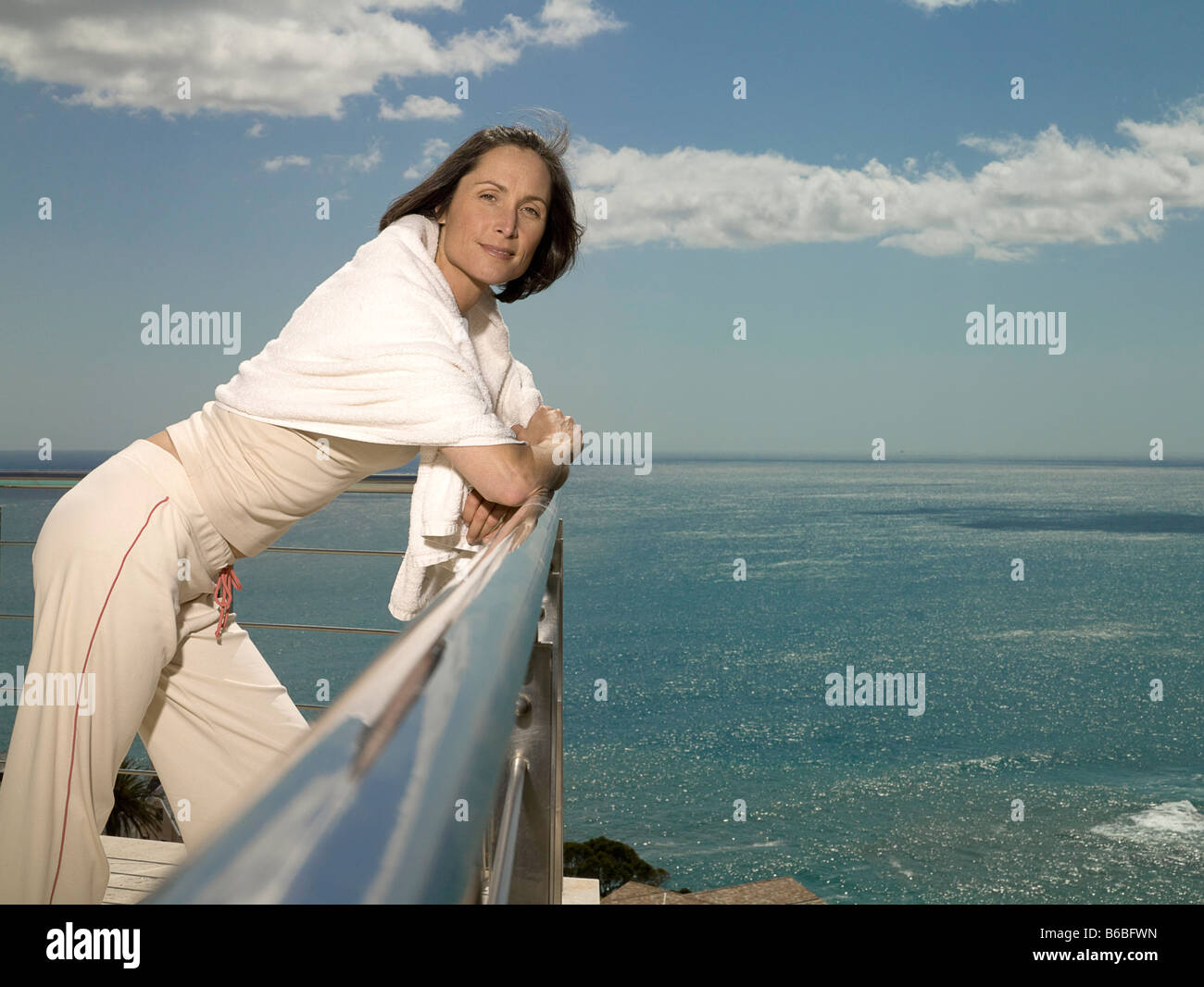 Portrait of woman leaning on railing Stock Photo - Alamy