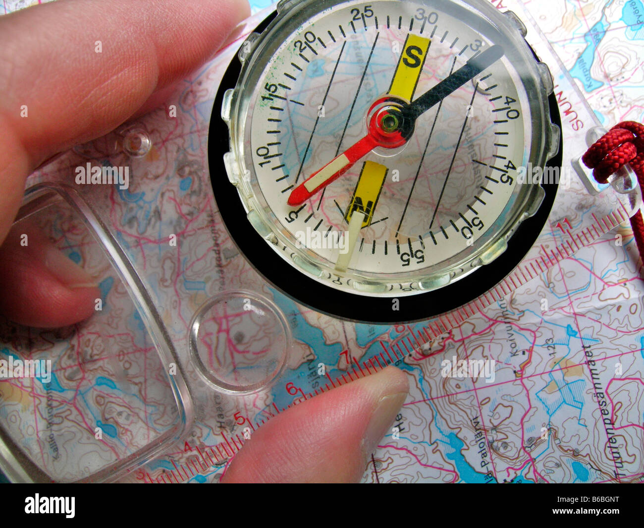 Close-up of person holding compass over map Stock Photo - Alamy