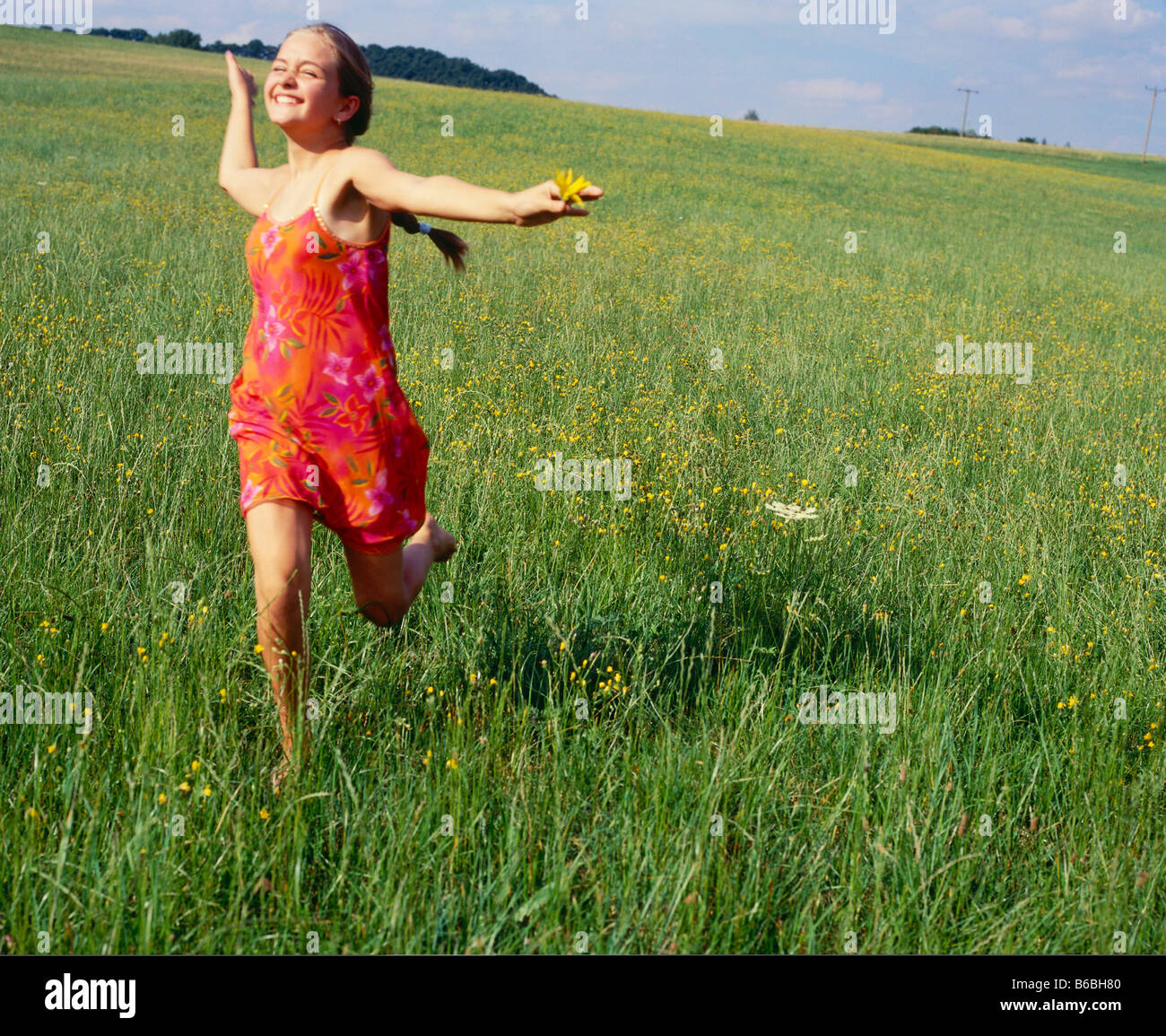 Teenage girl running in field Stock Photo - Alamy
