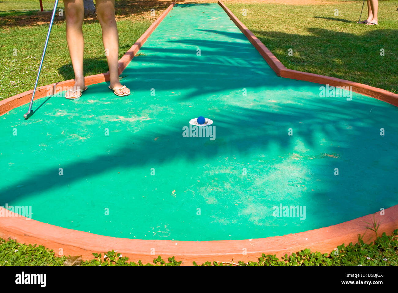 Low section view of woman playing miniature golf Stock Photo - Alamy