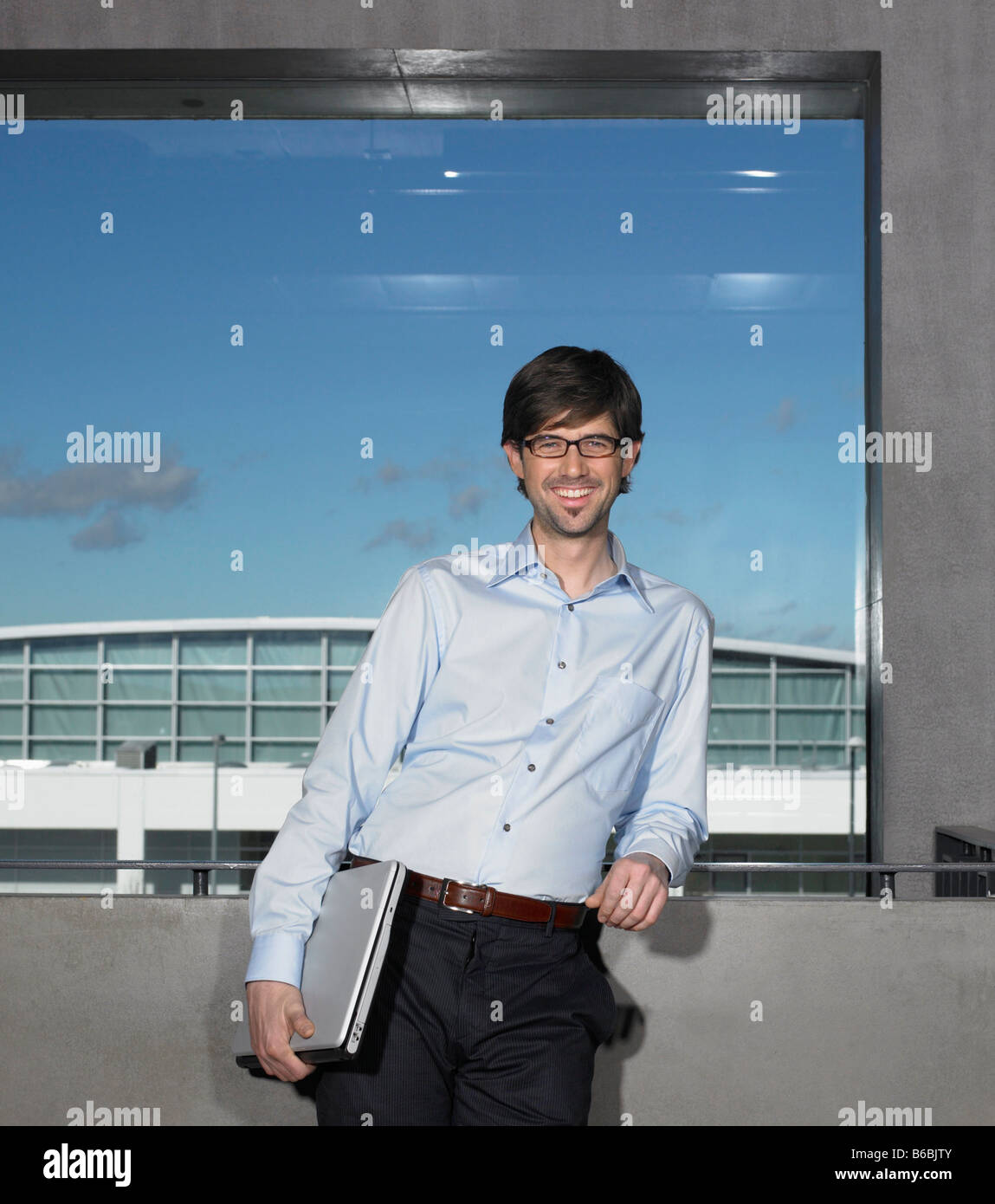 Portrait smiling businessman leaning against window hi-res stock ...
