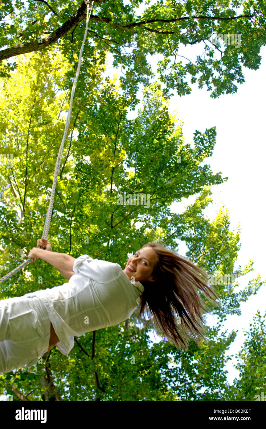 Woman swinging on rope and smiling Stock Photo - Alamy