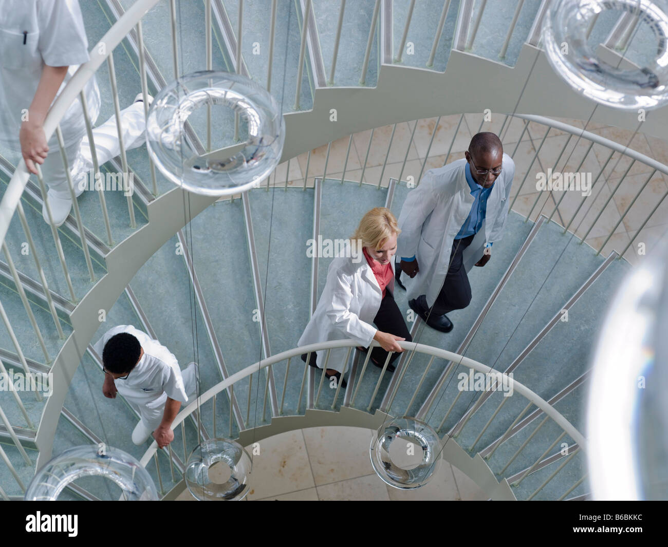Doctors moving on spiral staircase Stock Photo - Alamy