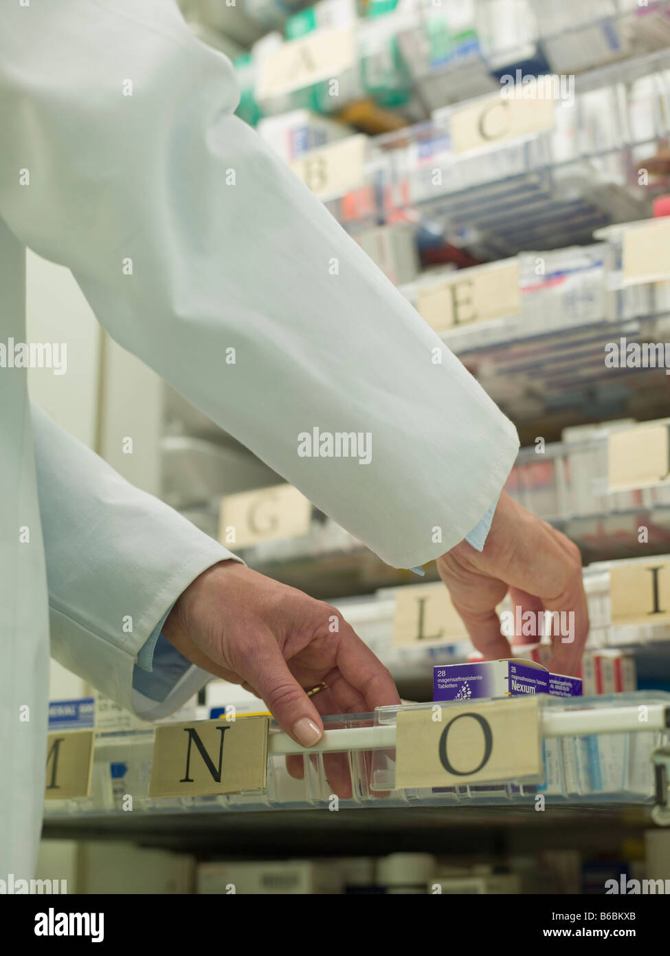 Doctor taking medicine from rack Stock Photo - Alamy