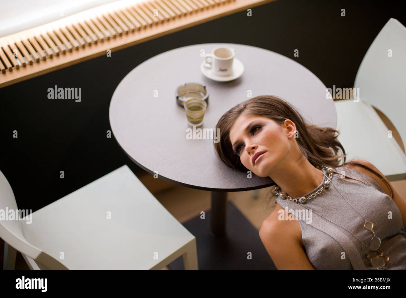 beautiful woman posing with her head on the table Stock Photo - Alamy