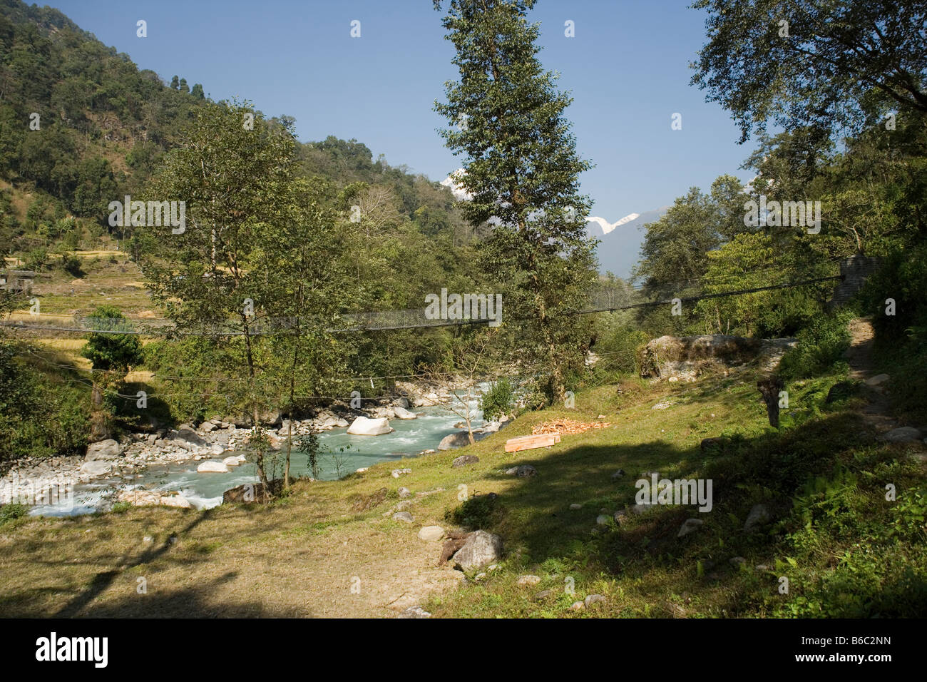 Metal rope bridge crossing the Modi river valley in the Annapurna range ...