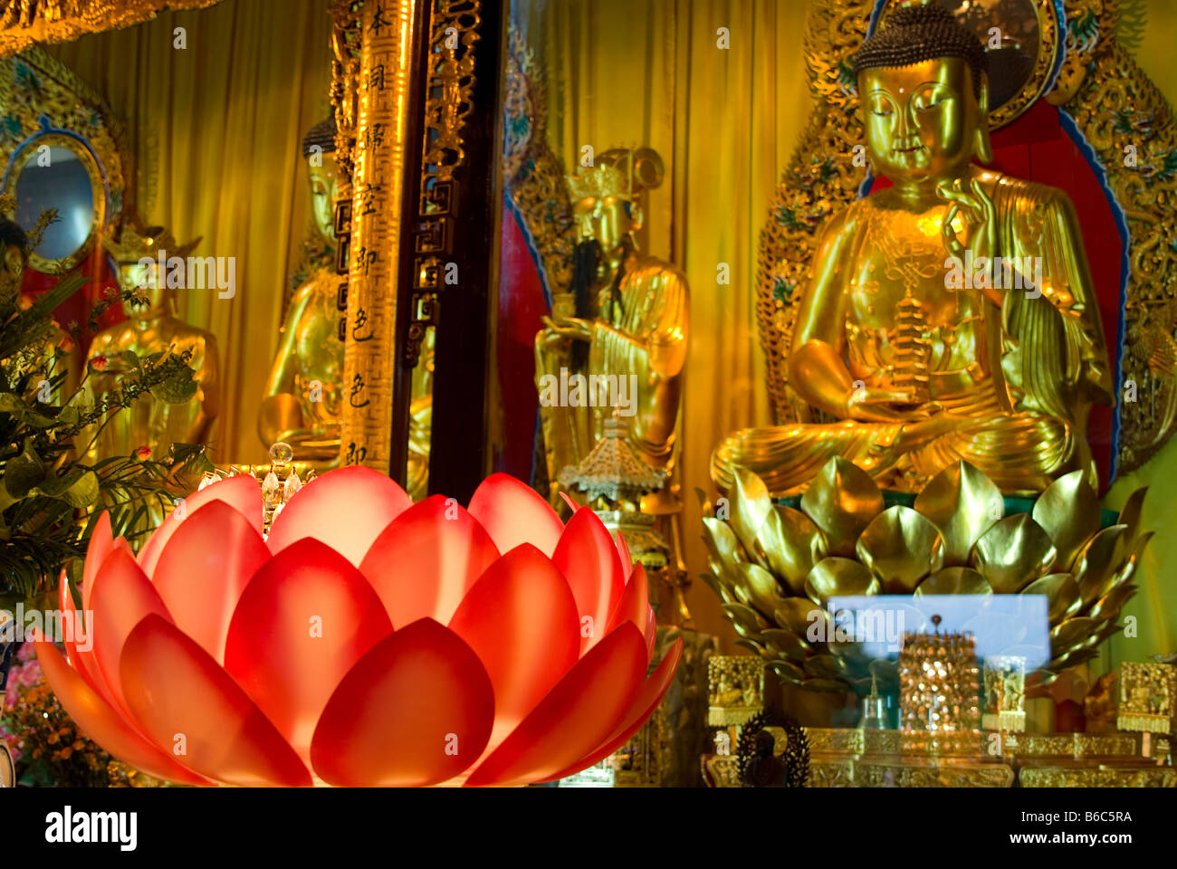 Shrine in the temple at Po Lin Monastery features gold Buddha statuary ...