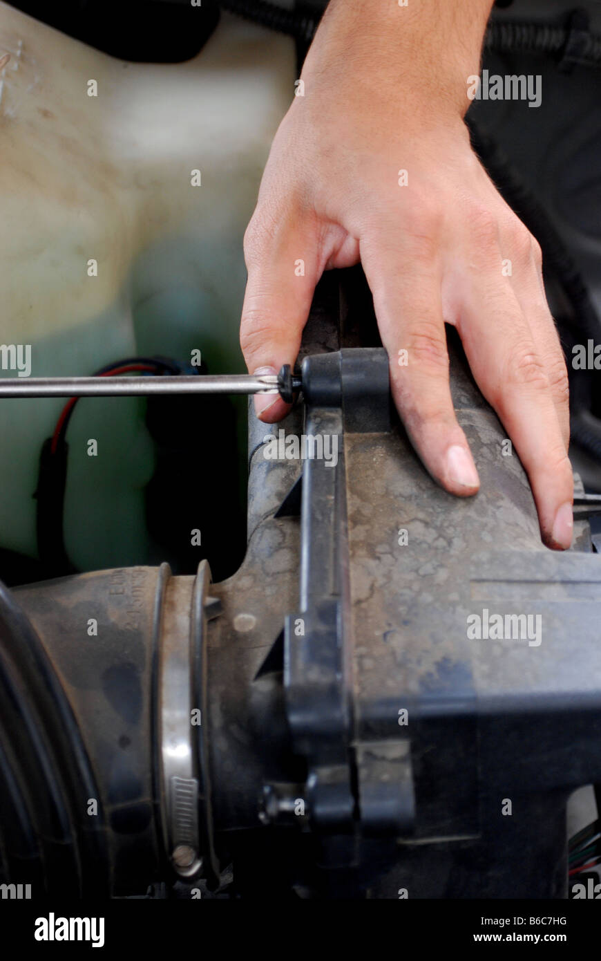 Mechanic turning a screw while fixing an engine Stock Photo - Alamy