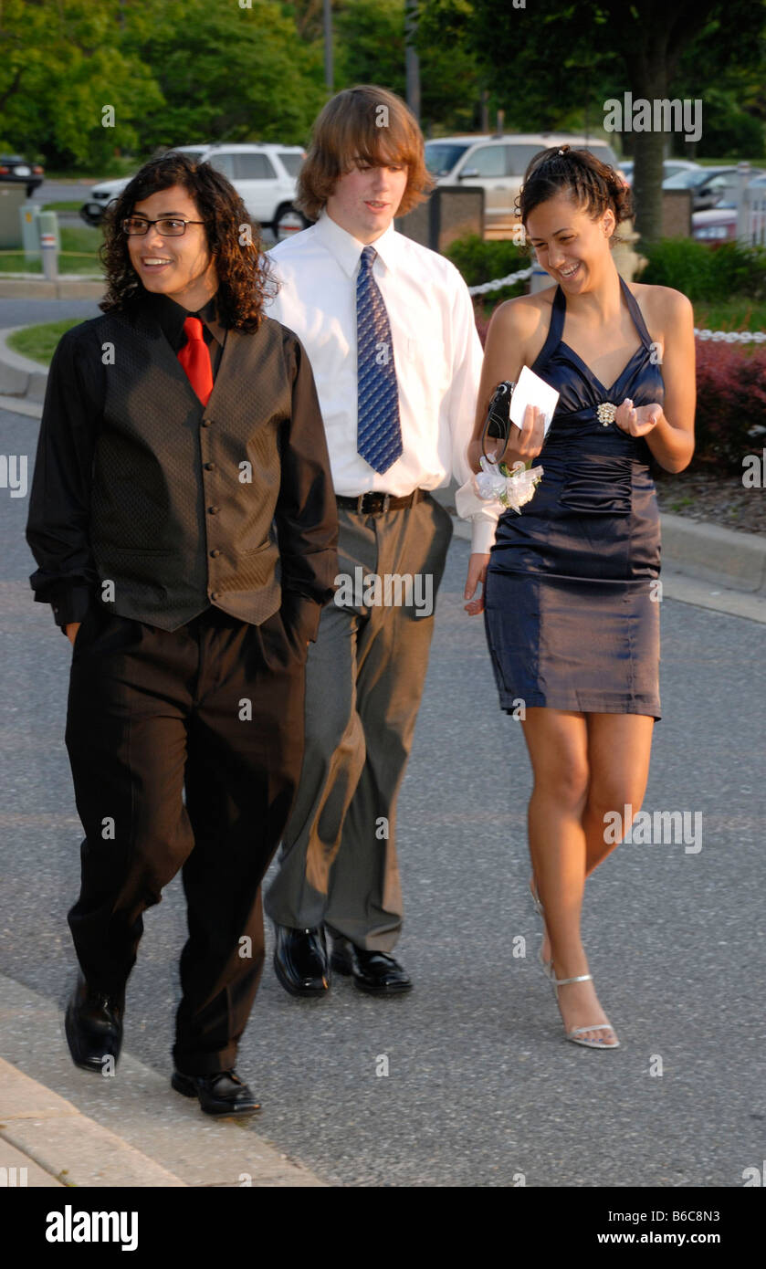 High school teen friends walk down the street to their high school prom ...