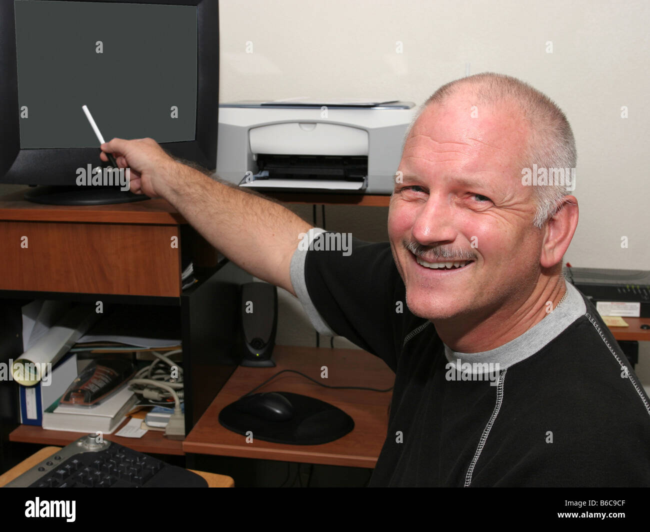 A meteorologist pointing to his computer monitor and reporting good ...