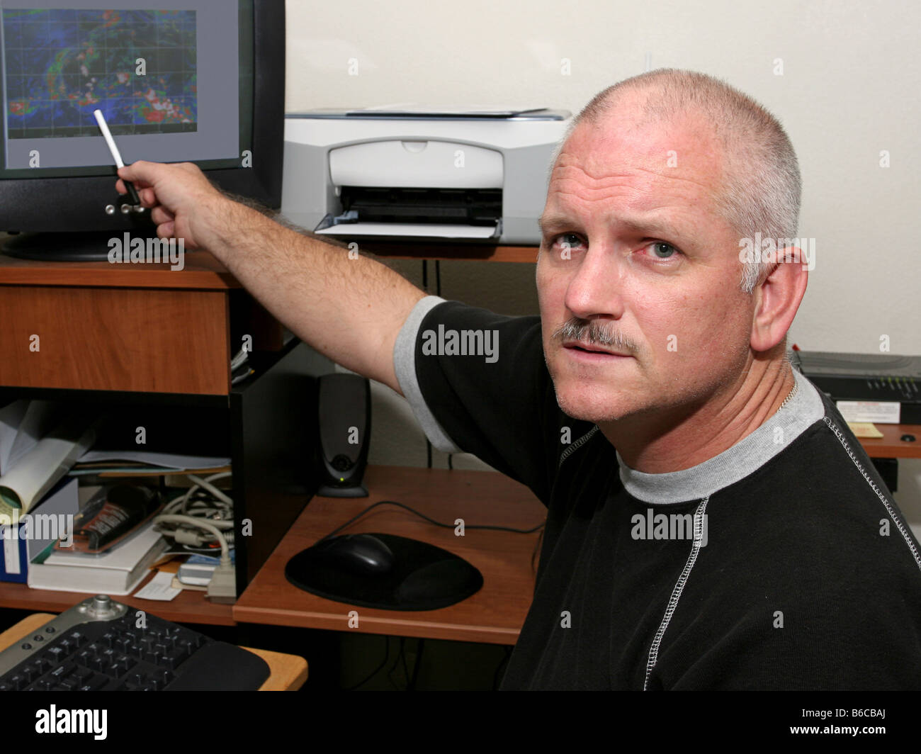 A meteorologist pointing out a hurricane developing He has a serious ...