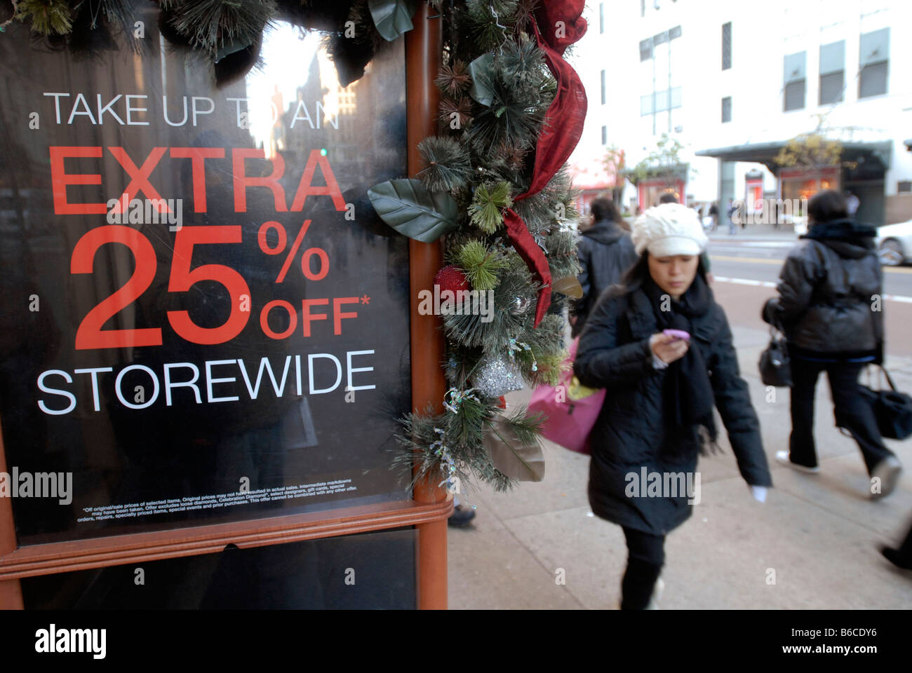 Shoppers pass sale signs in stores in the Herald Square shopping ...