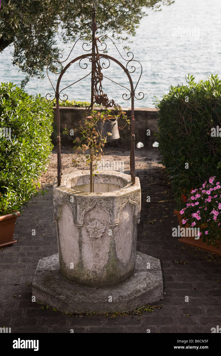 Antique marble well in a private garden in Sirmione waterfront lake ...