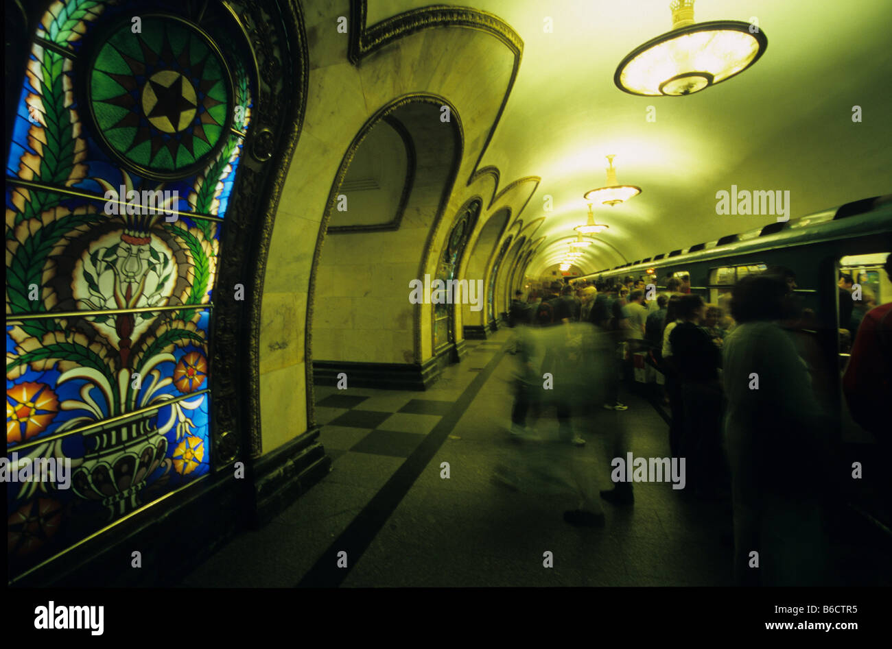 Passengers at lit up subway station Stock Photo - Alamy