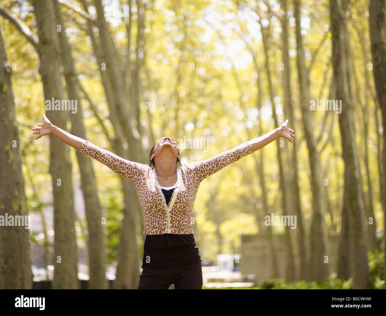 Mixed race woman with arms outstretched in park Stock Photo - Alamy