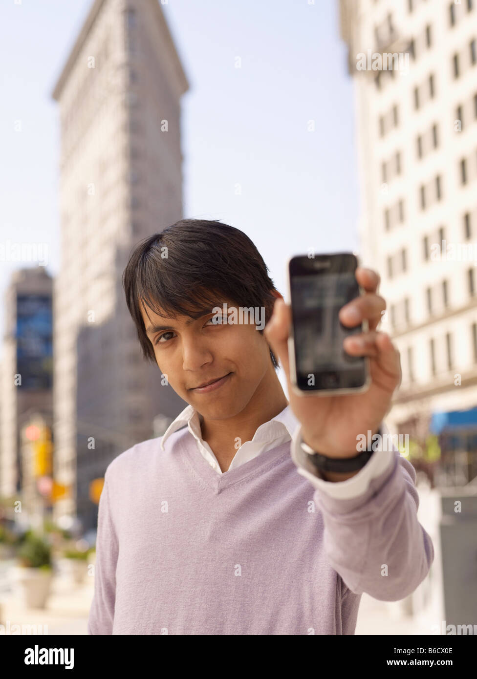 Indian man holding out cell phone Stock Photo - Alamy