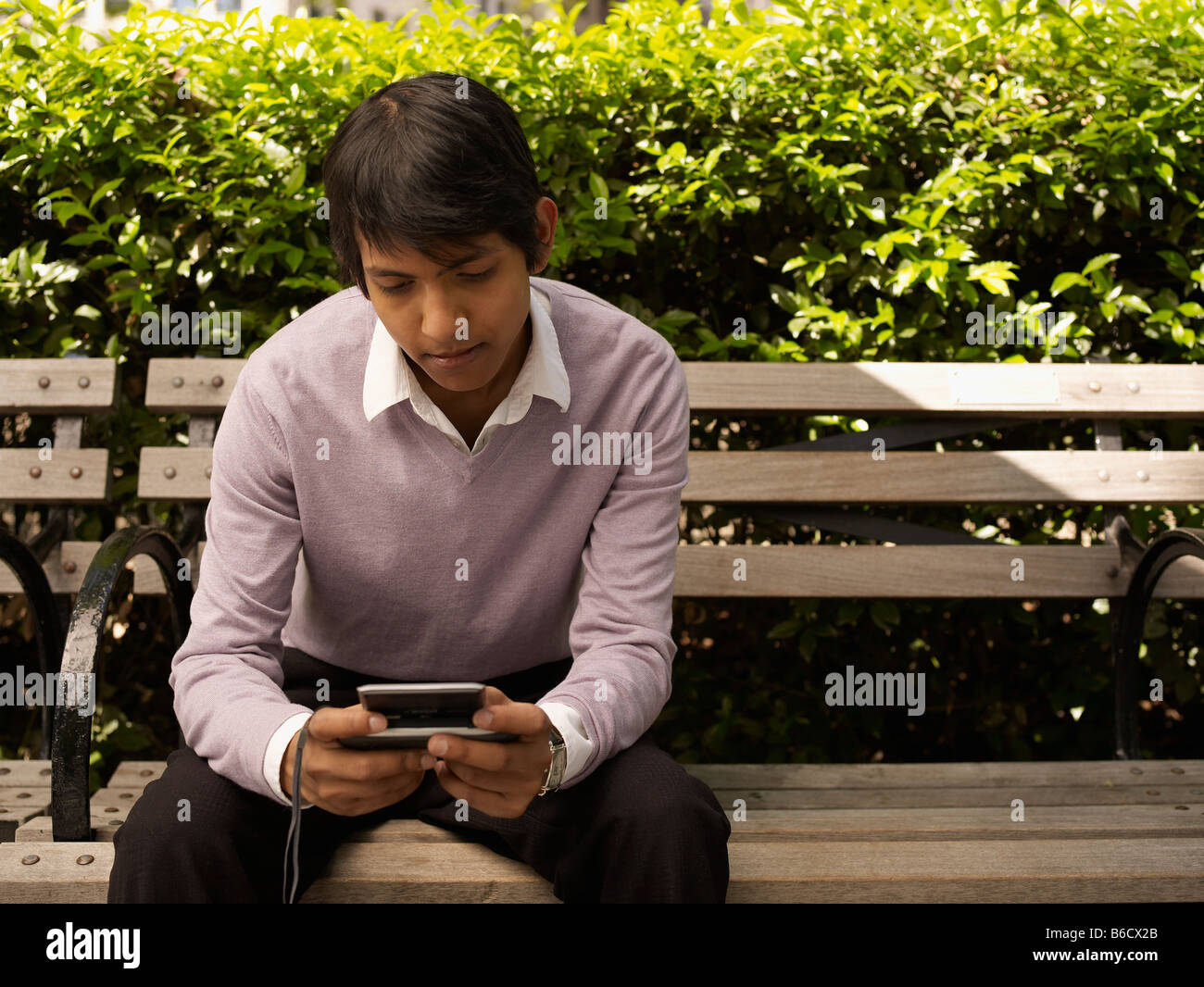 Indian man text messaging in park Stock Photo - Alamy