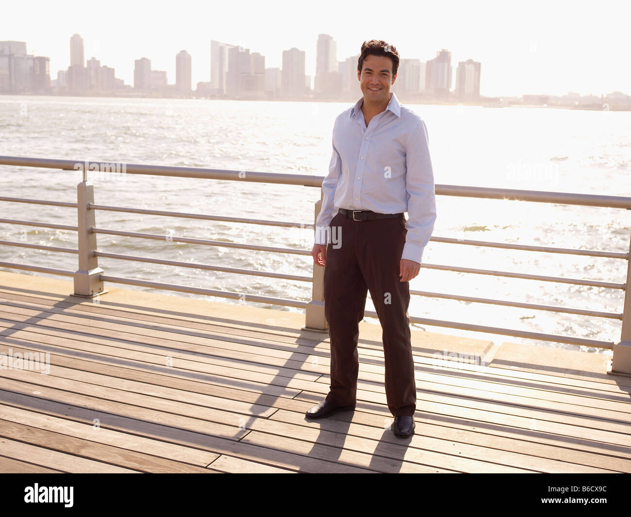 Man standing on boardwalk on waterfront Stock Photo - Alamy