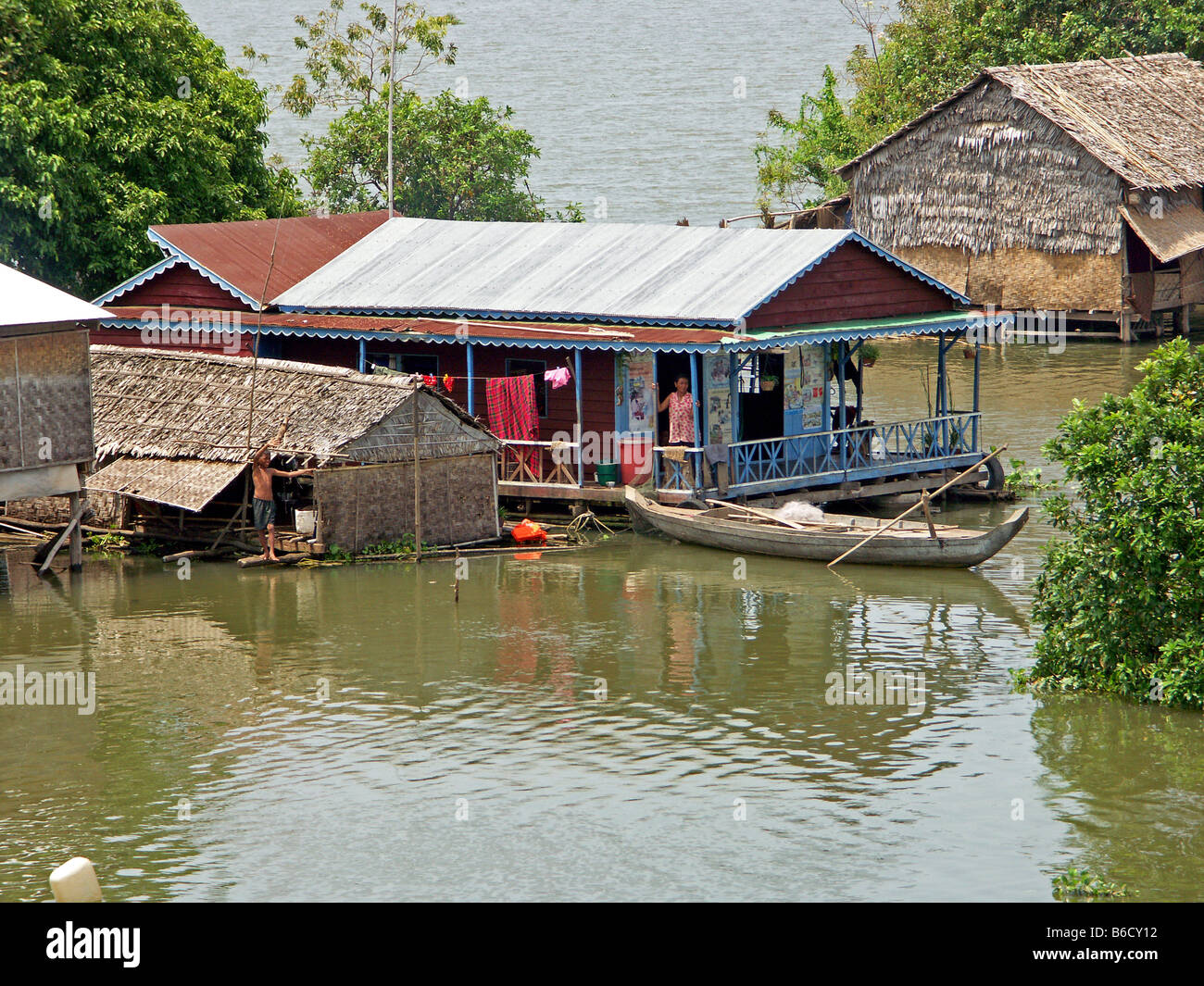 People in houses on river Stock Photo - Alamy