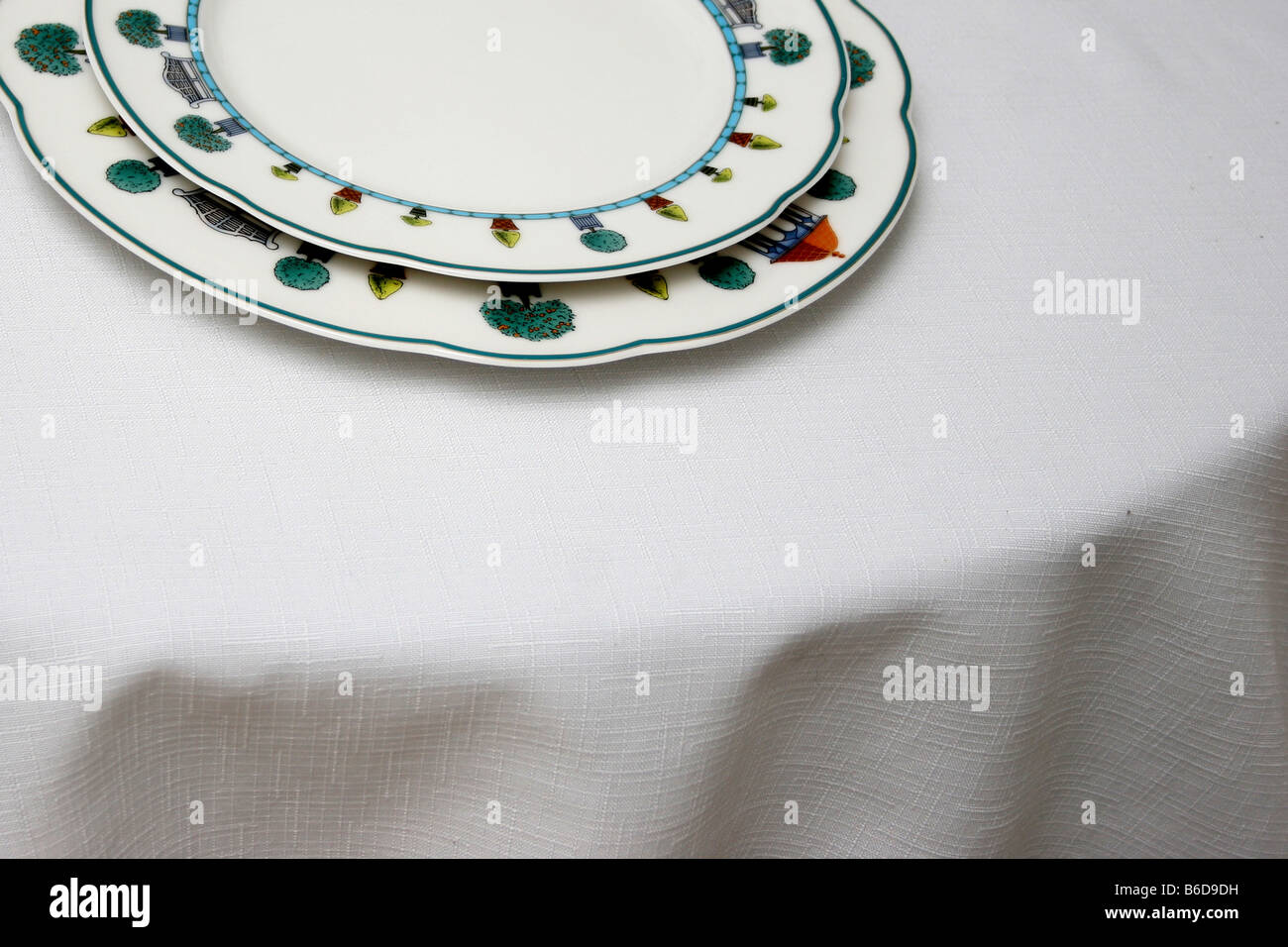 A set of plates on white tablecloth Stock Photo - Alamy