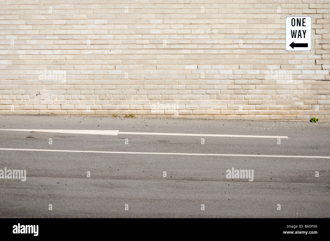 One way sign and arrow on wall with arrow on road also Stock Photo - Alamy