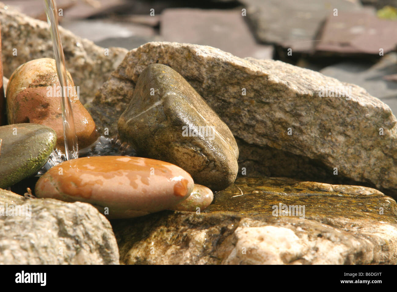 Water running over rocks and pebles Stock Photo - Alamy