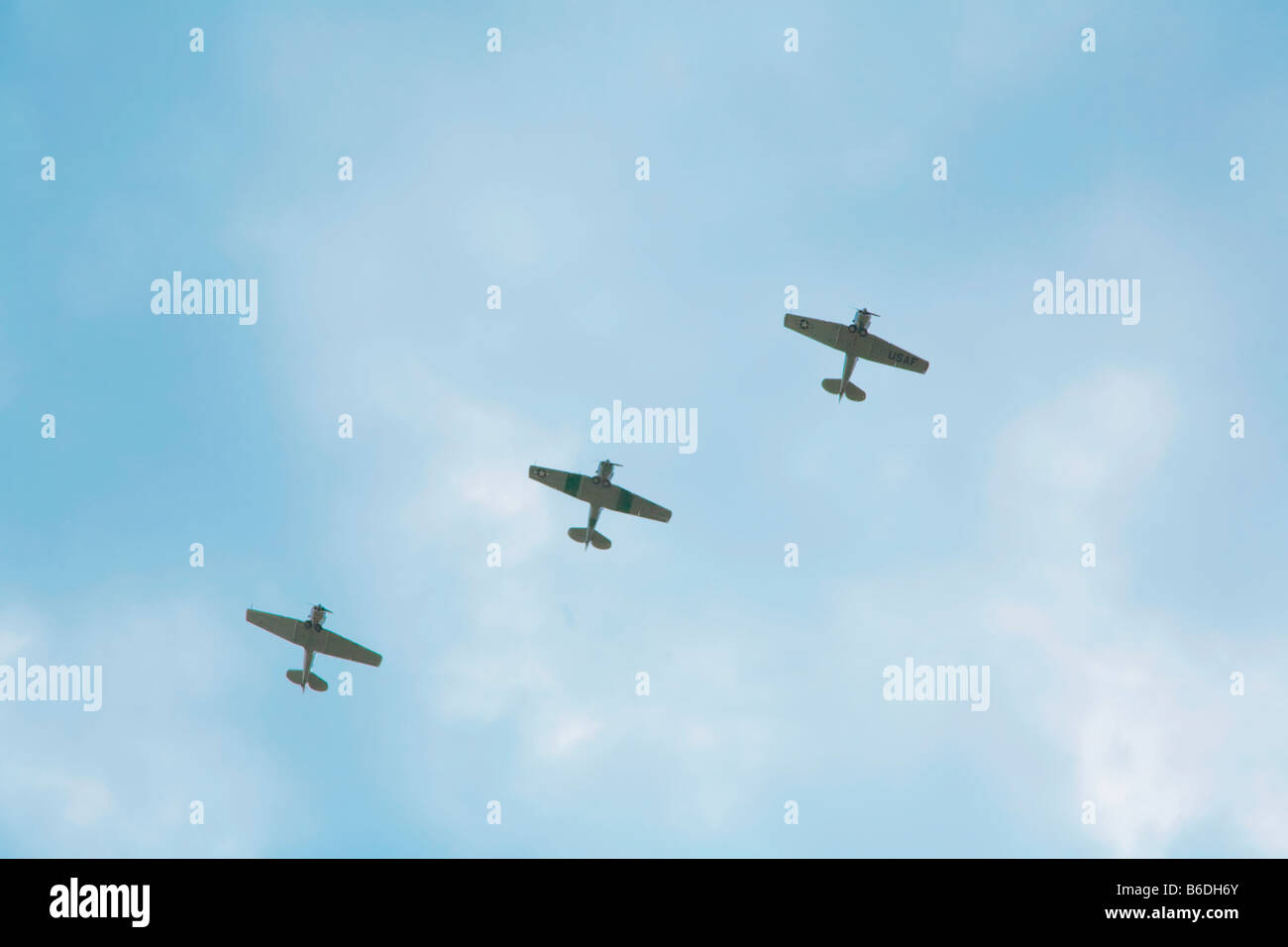 Three propeller aircraft flying in formation in a cloudy blue sky Stock ...