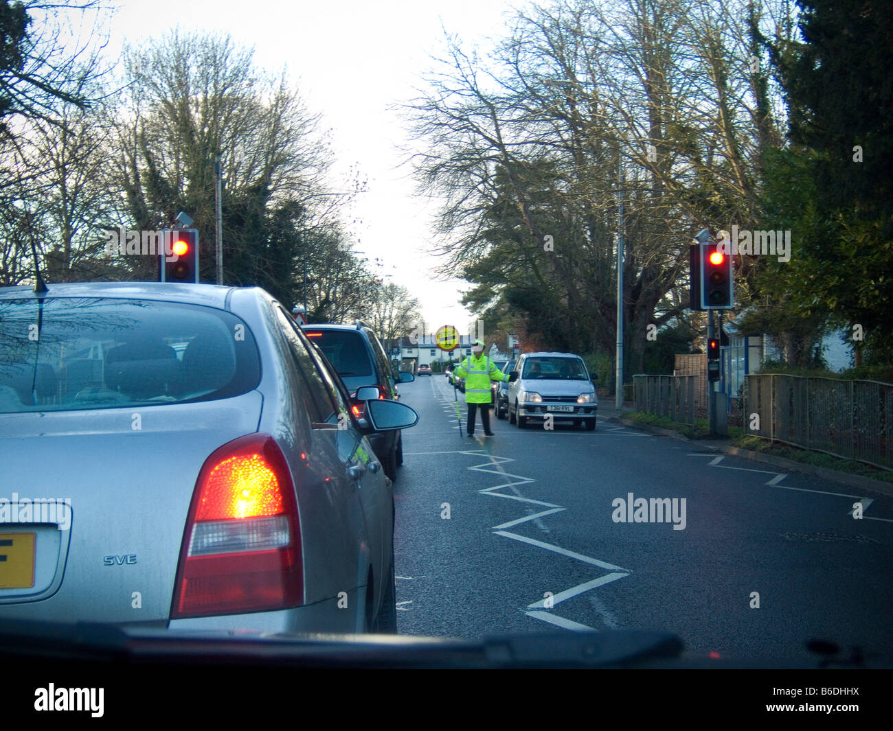 A lollypop lady stops traffic at a school crossing Stock Photo - Alamy