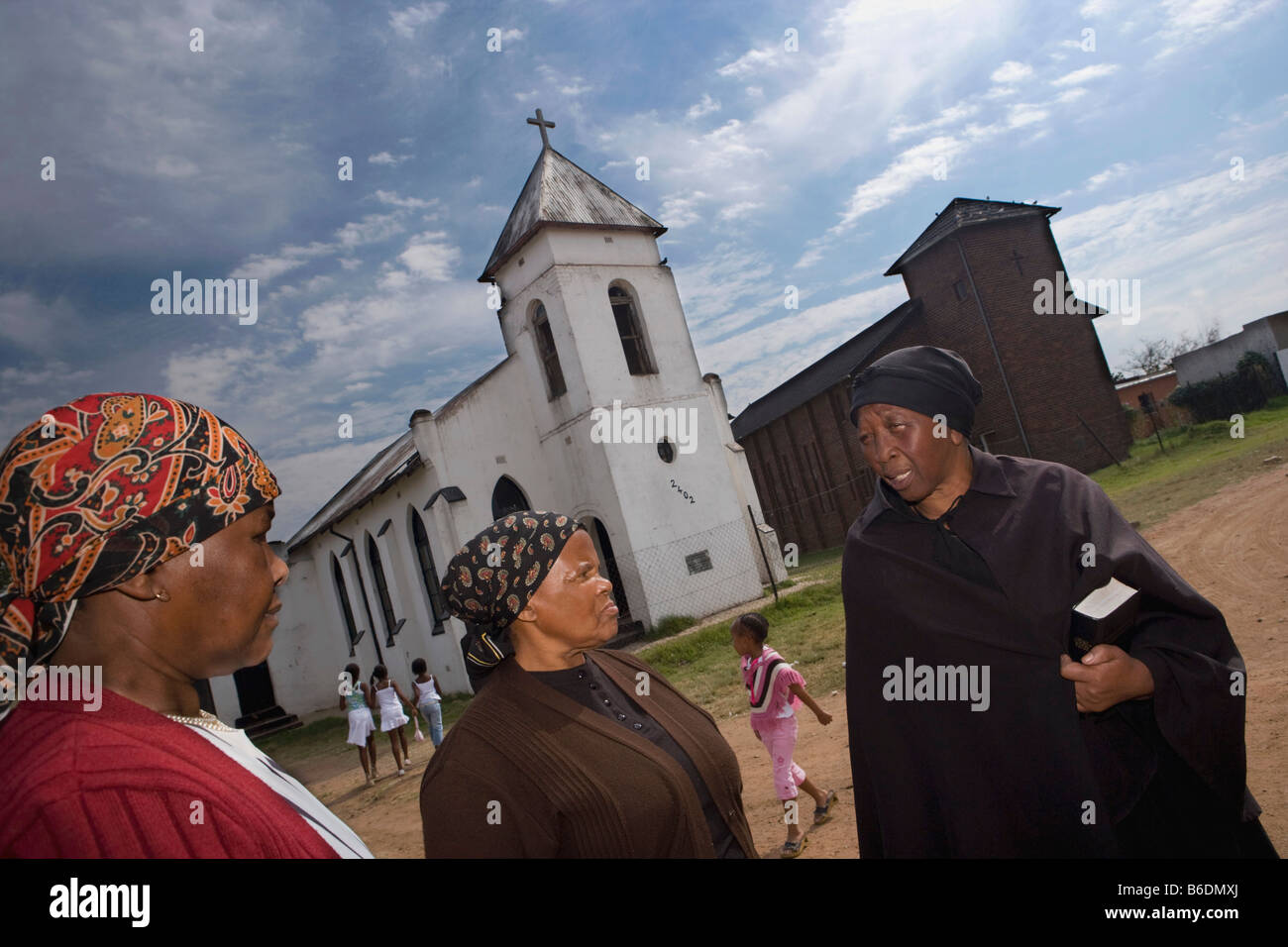 South Africa, Johannesburg, Soweto, Women with bible chatting in front ...