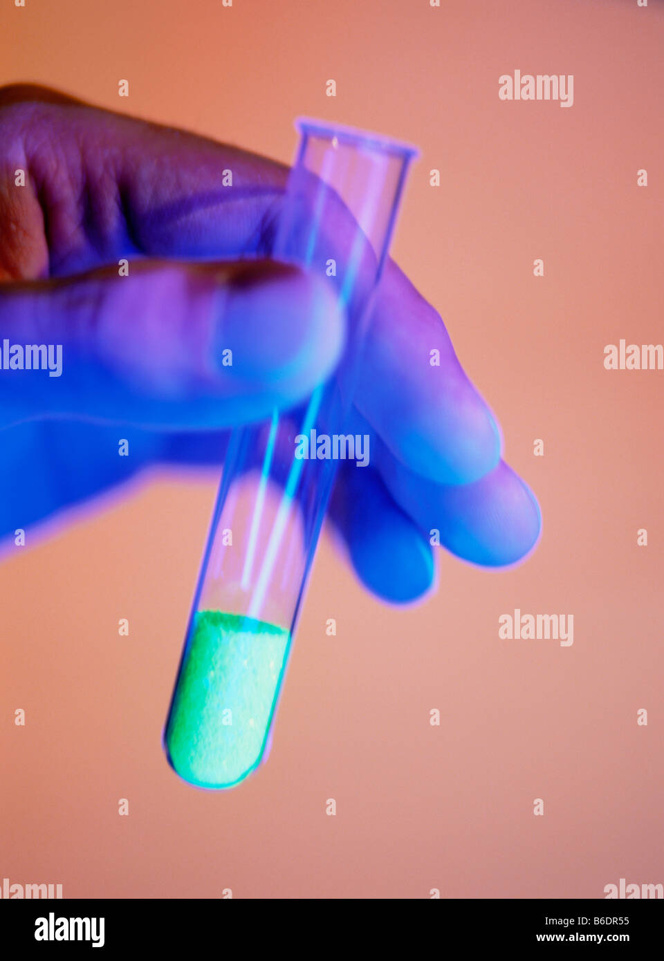 Test tube containing a solid, fluorescent chemical that is glowing ...