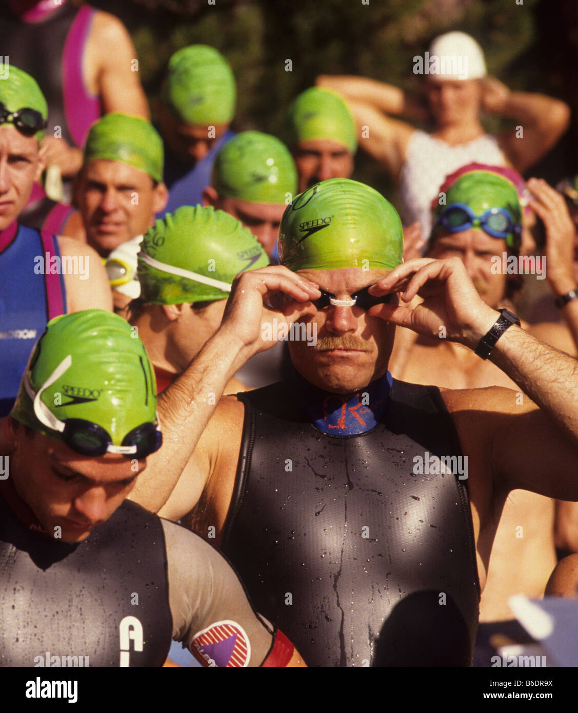 Macho male swimmer adjusts his swimming goggles before going for a swim ...