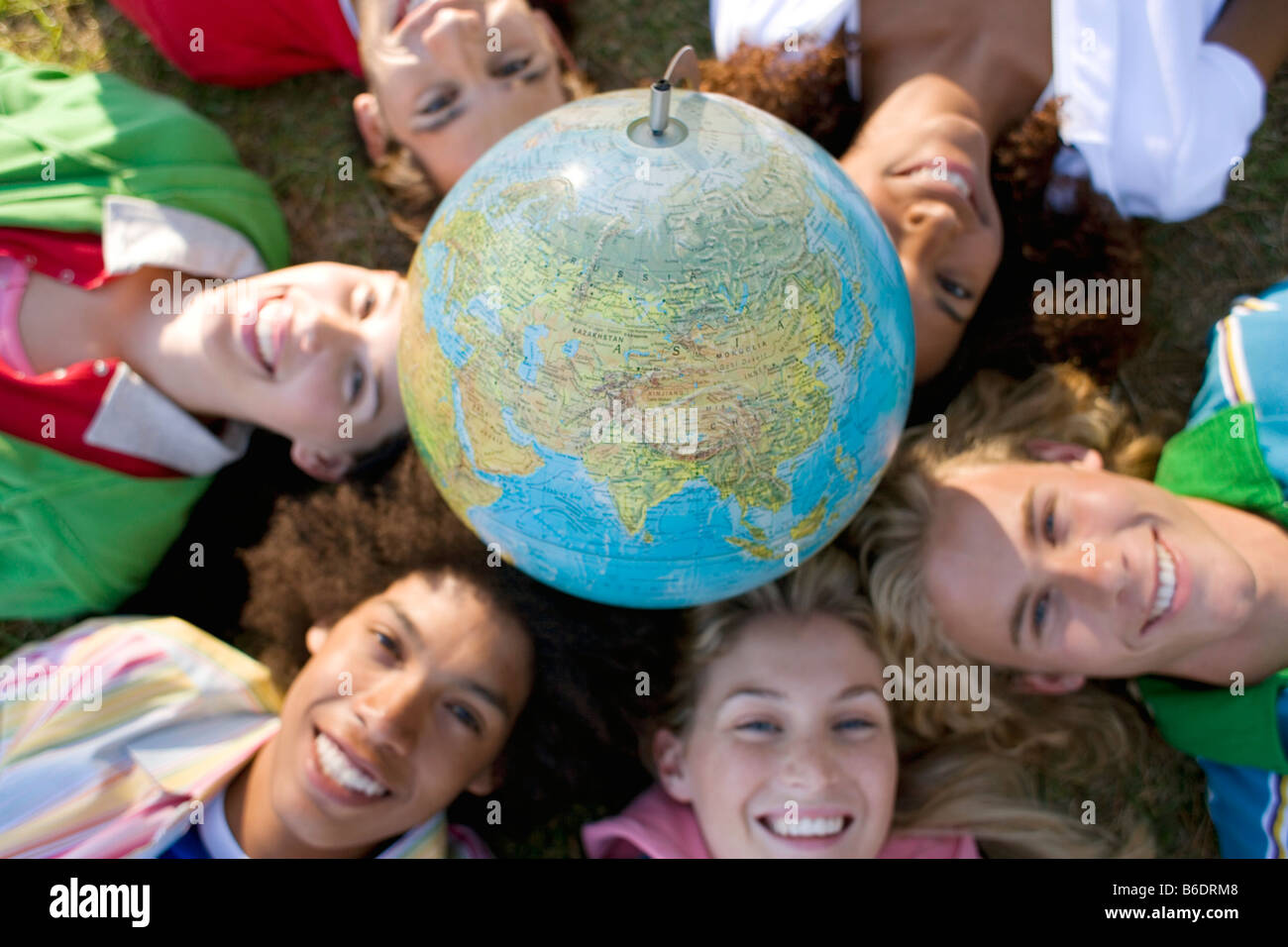 Environmental awareness. Group of friends lying down in a circle with a ...