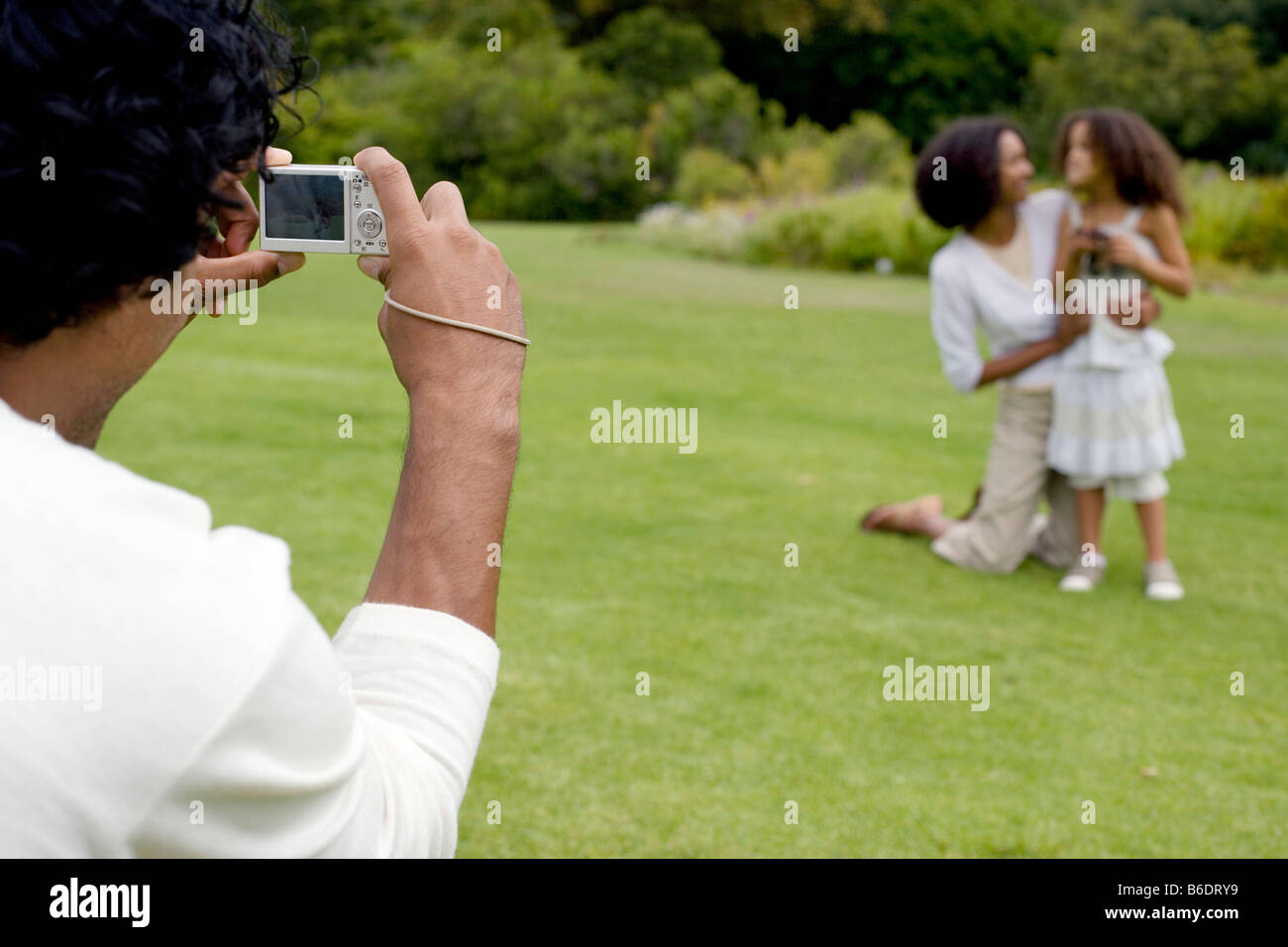 Digital camera use. Father taking a photograph of his partner and ...
