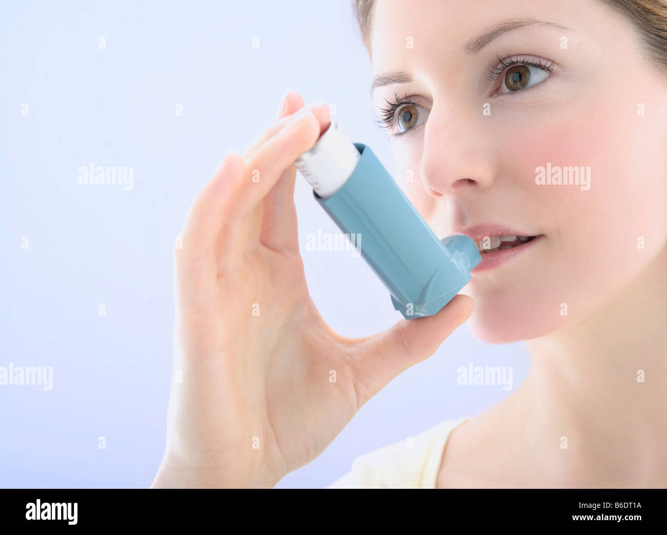 25 year old woman using an inhaler to treat an asthma attack Stock ...