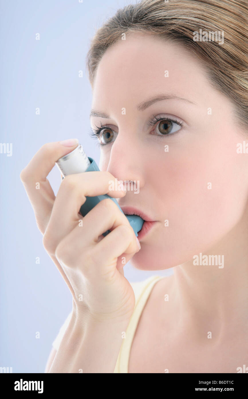 25 year old woman using an inhaler to treat an asthma attack Stock ...
