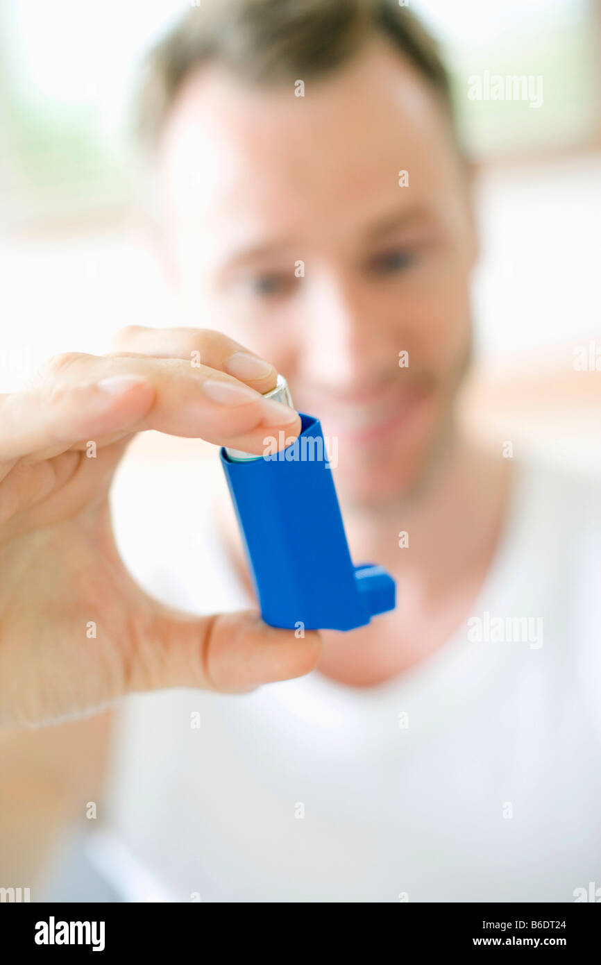 Man using an inhaler to treat an asthma attack Stock Photo - Alamy
