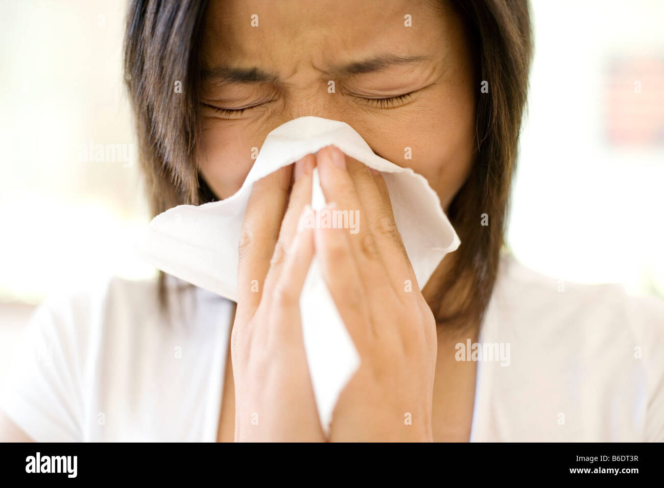 Woman sneezing into a handkerchief Stock Photo - Alamy