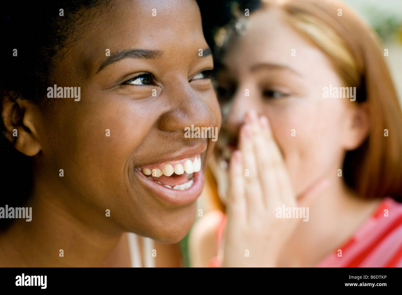 Girl Whispering Into Teenage Girls Ear High Resolution Stock ...
