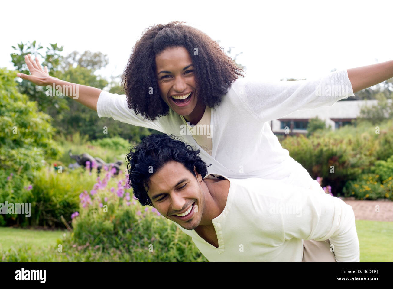 Happy couple. Woman being carried on her partner's back Stock Photo - Alamy