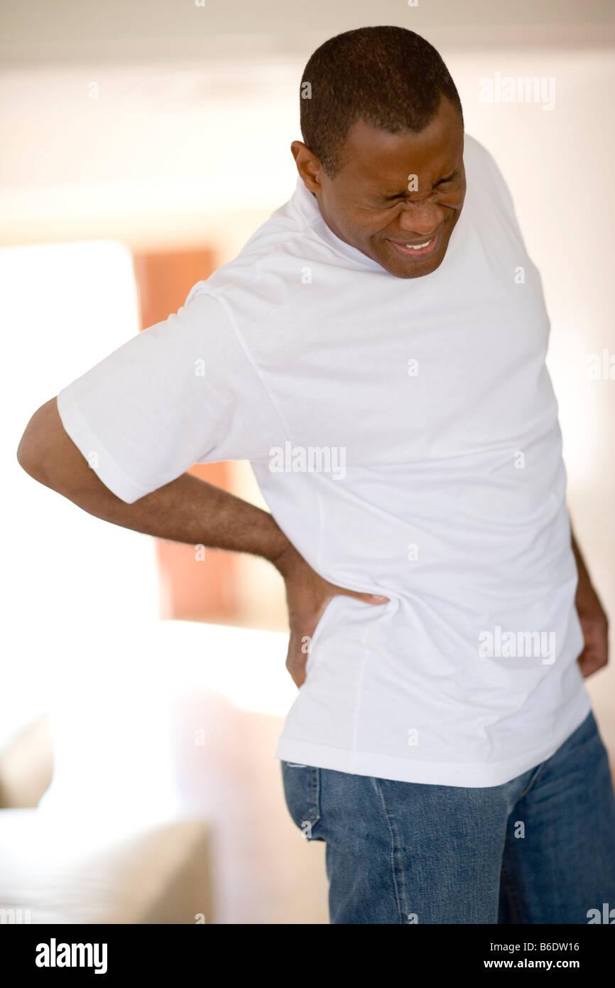 Man holding his painful lower back, backpain is a very common complaint ...