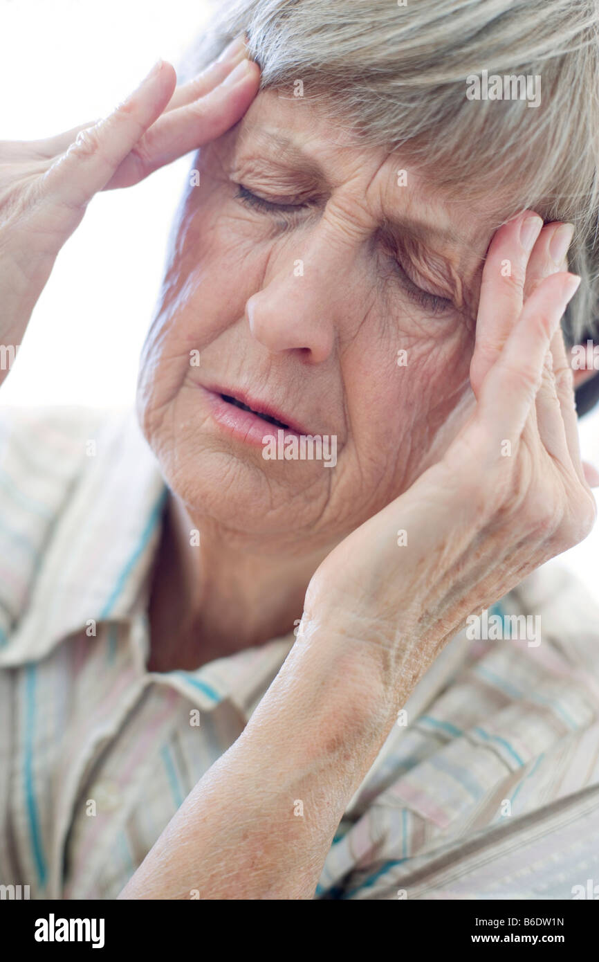 Woman pressing her aching temples Stock Photo - Alamy