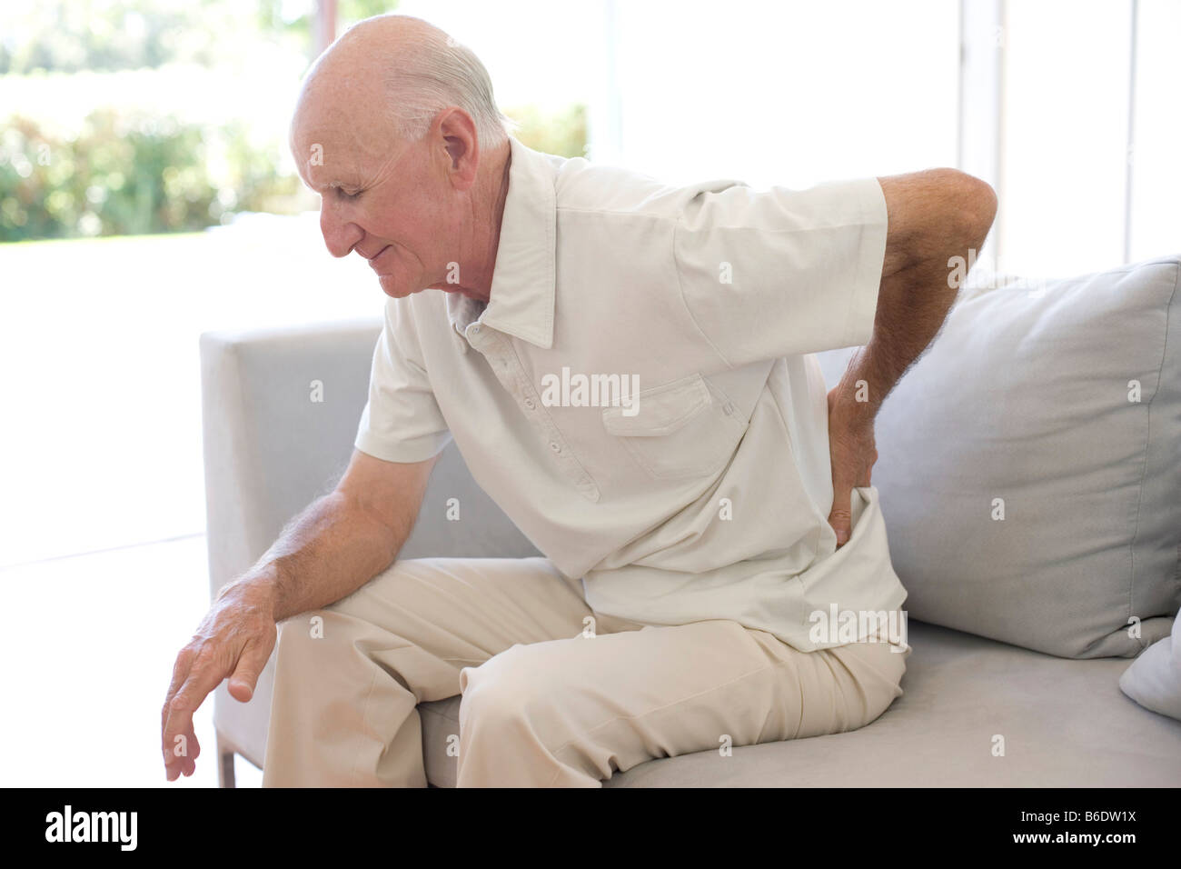 Man rubbing his aching back Stock Photo - Alamy