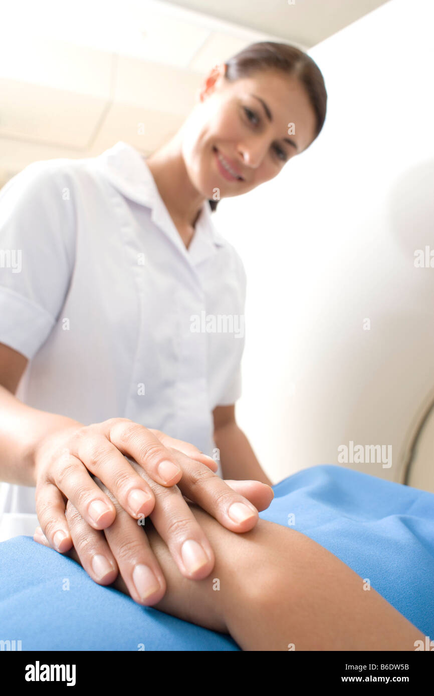 CT scanning. Radiographer preparing a patient about to undergo a CT ...