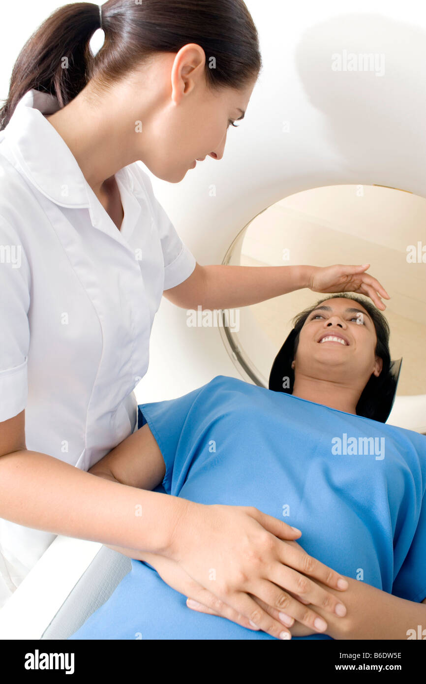 CT scanning. Radiographer preparing a patient about to undergo a CT ...