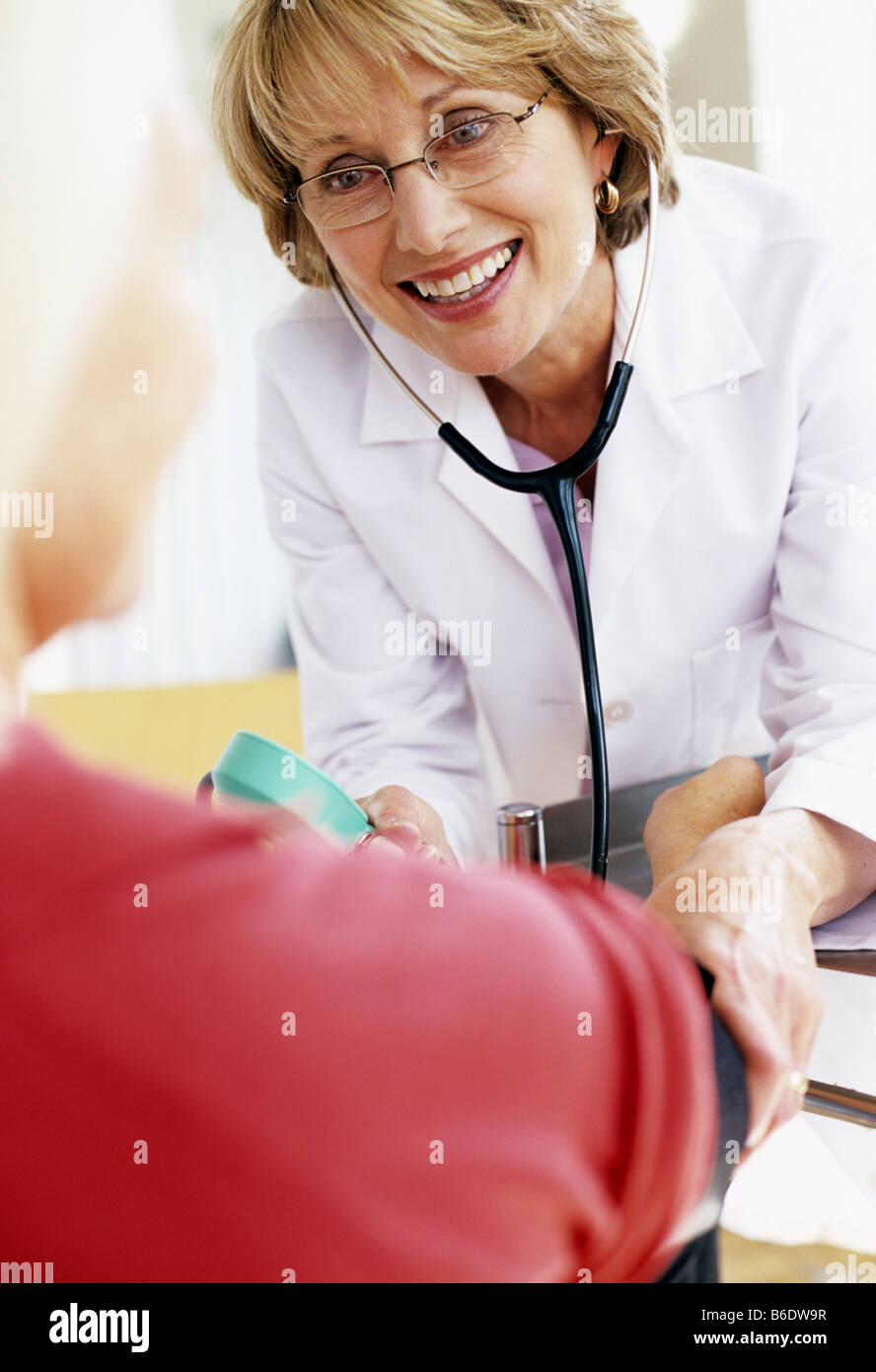 Blood pressure measurement. Sphygmomanometer and stethoscope being used ...