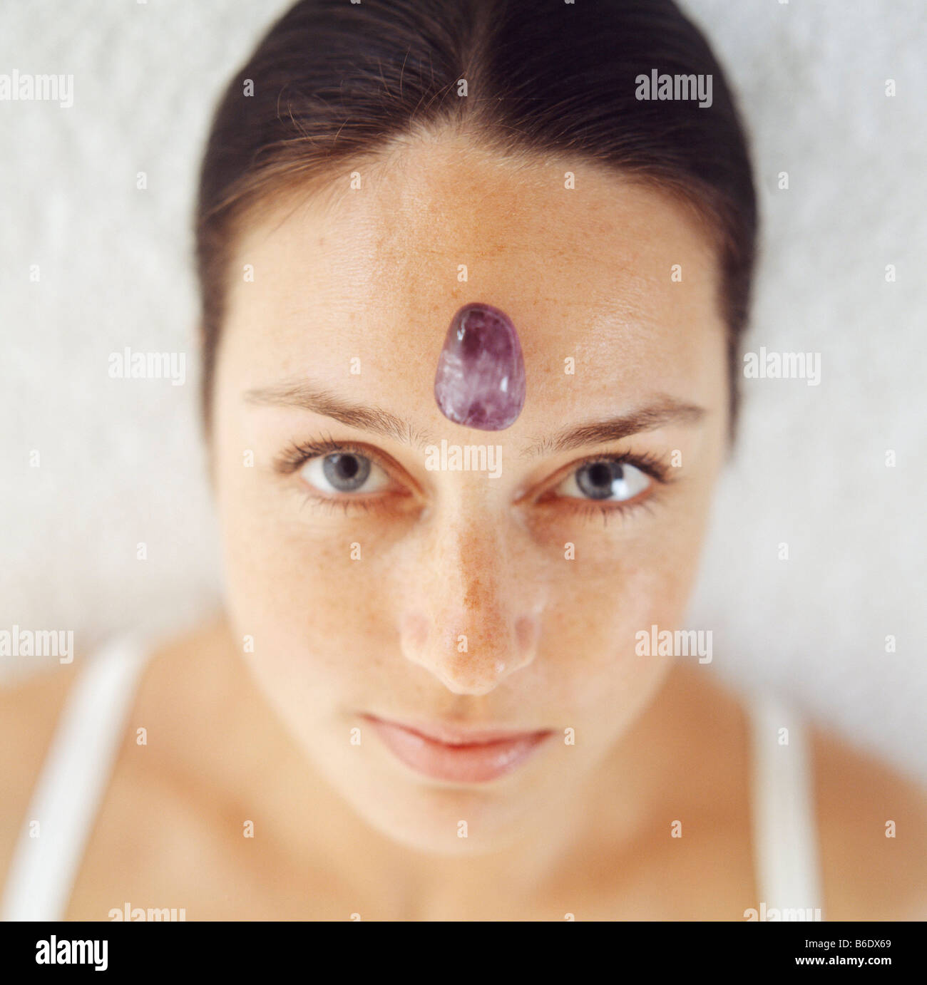 Woman with healing crystal on her forehead, Crystal therapists believe ...