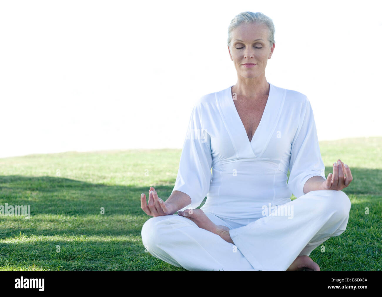 Meditation. Woman sitting in the lotus position Stock Photo - Alamy