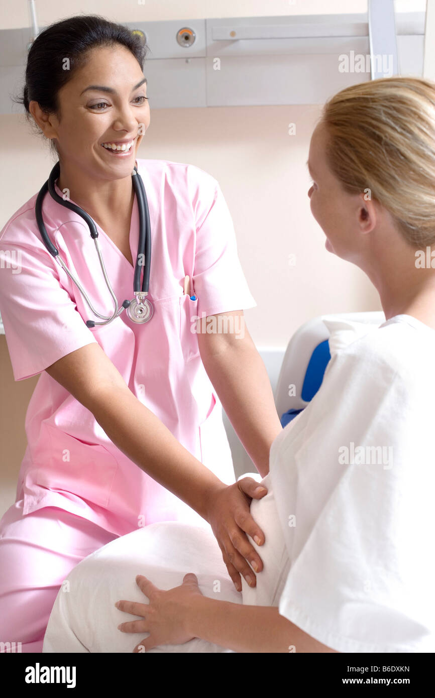 Pregnancy check-up. Obstetrician feeling a pregant woman's abdomen to ...