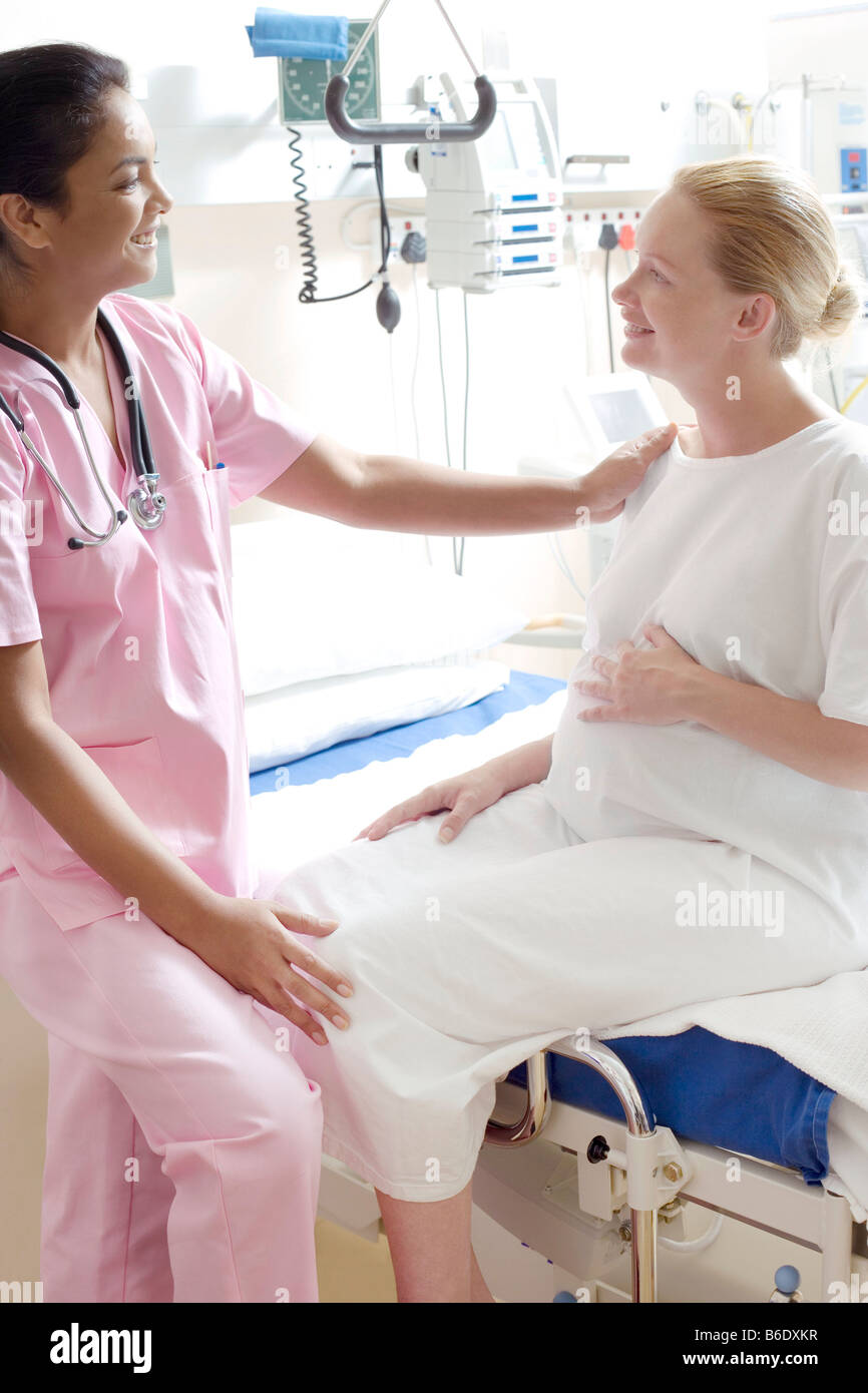 Pregnancy check-up. Obstetrician talking with a pregnant woman on a ...