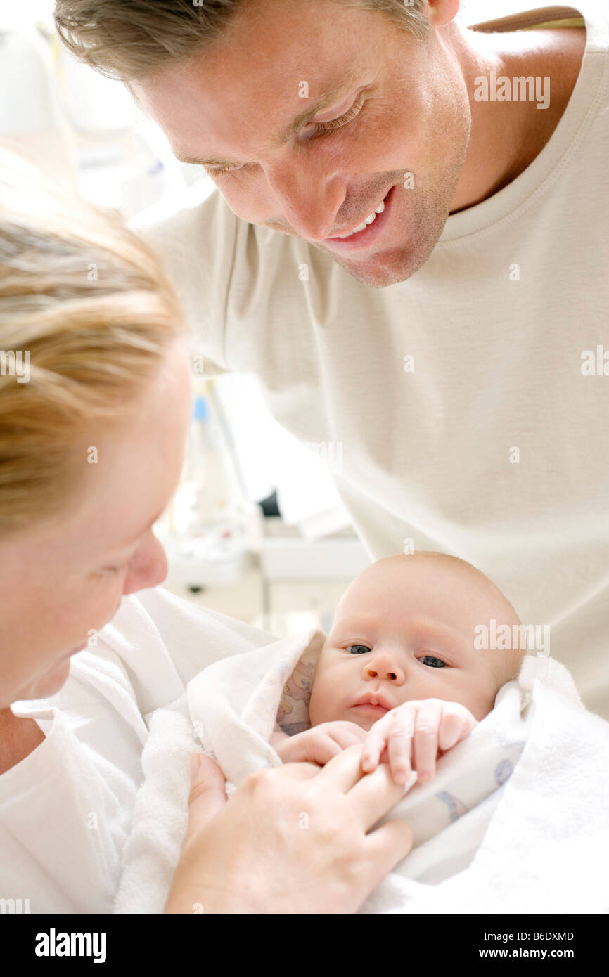 Parents and newborn baby. Mother and father in a maternity ward holding ...